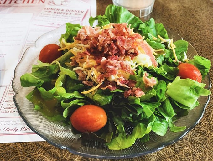 Fresh greens topped with bacon bits and cheese show that even the salad bar gets the royal treatment.