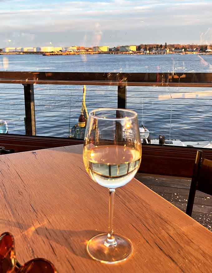 Crisp white wine overlooking the working harbor at sunset, because some moments deserve to be savored slowly with good company.