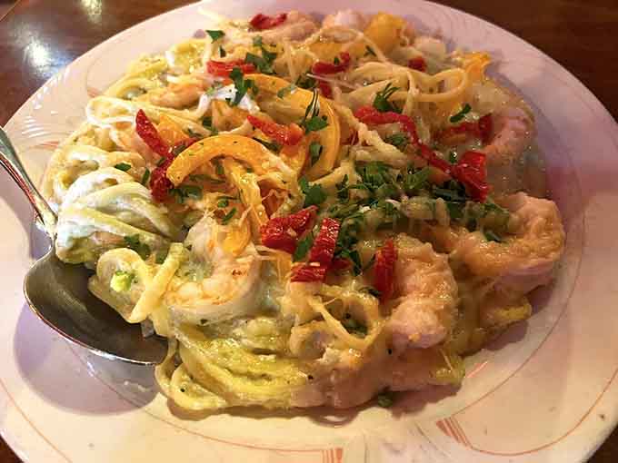 Pesto alfredo pasta loaded with shrimp creates a dish that's basically a vacation to the Italian coast.