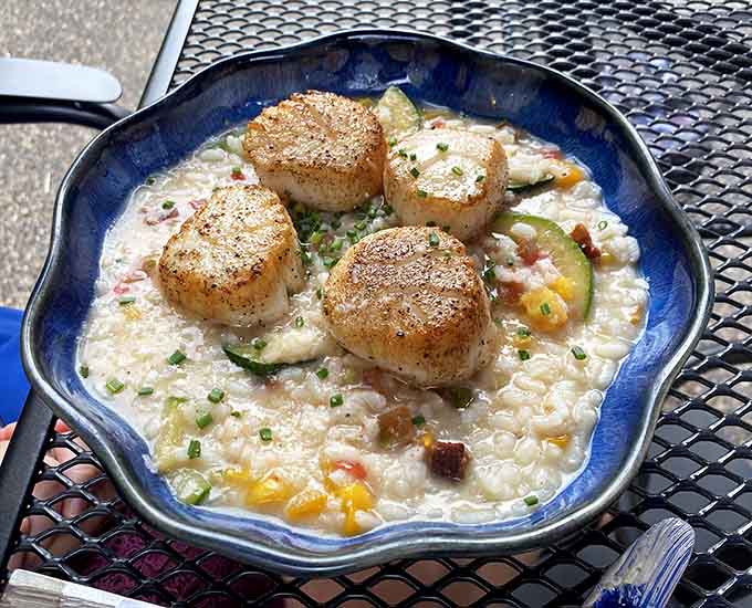 Perfectly seared scallops nestle into a creamy risotto that proves the kitchen knows how to treat premium seafood with the respect it deserves.