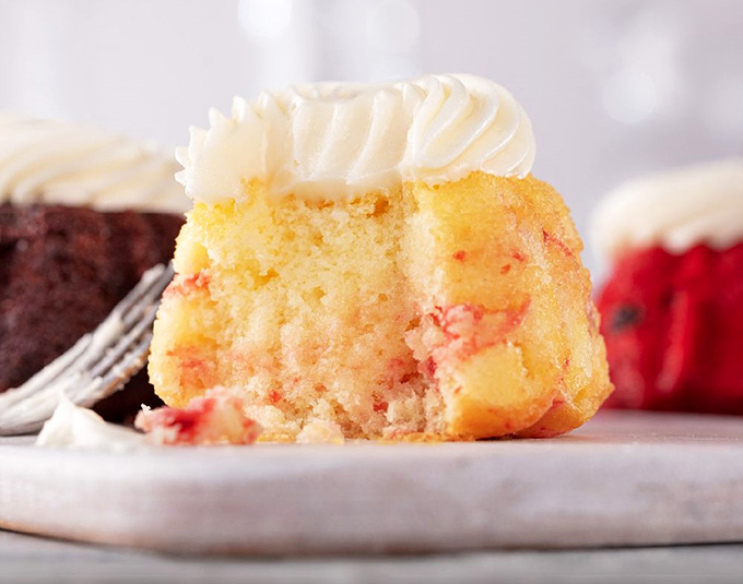 White Chocolate Raspberry bundtlet looking like it just stepped out of a dessert magazine photo shoot.