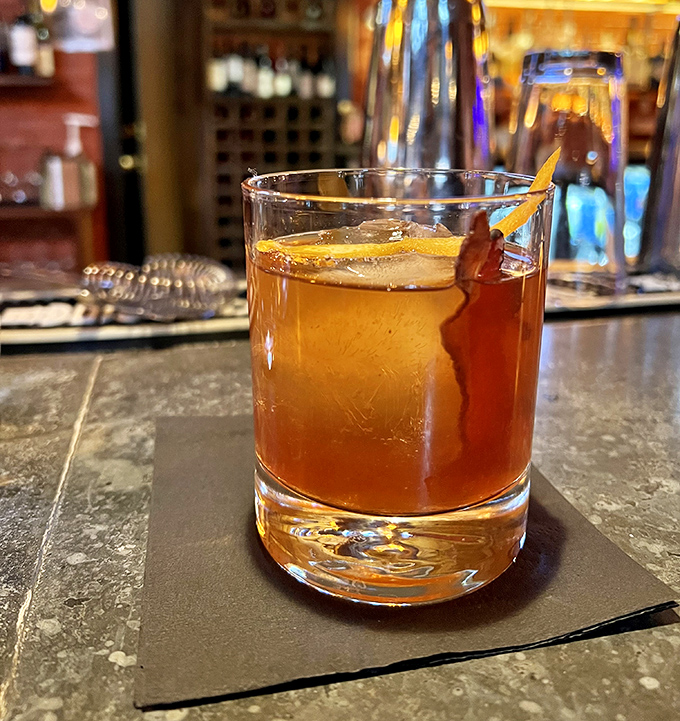 An Old Fashioned done right – amber liquid, proper dilution, large ice cube, and orange peel – Don Draper would approve.