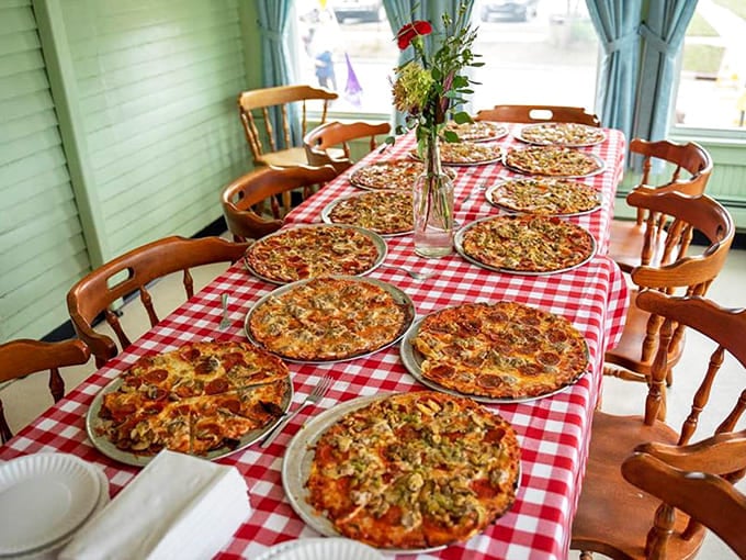 A pizza feast spread across checkered tables, the kind of sight that makes you want to cancel your dinner plans for the next week.