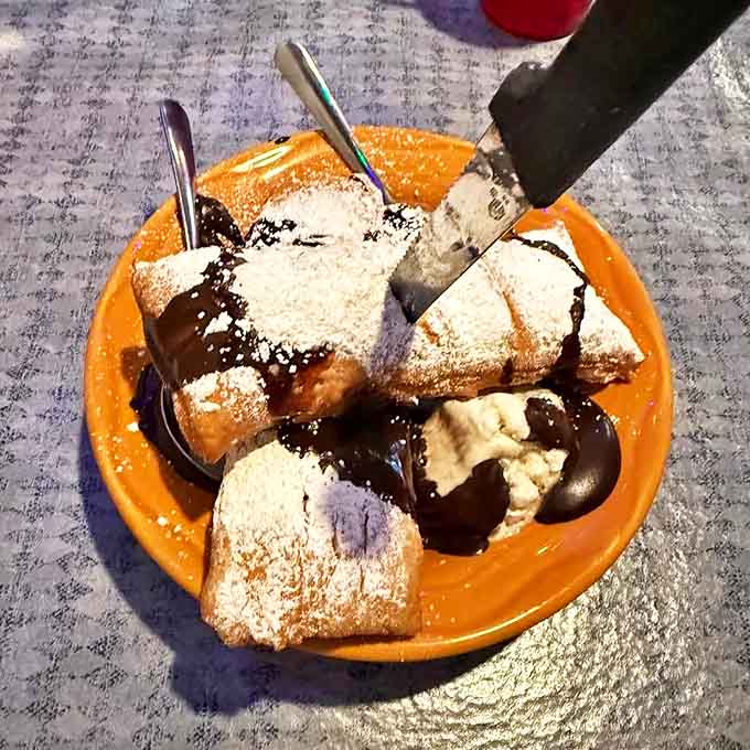 Beignets showered in powdered sugar—the kind of dessert that makes you not care that you're wearing half of it on your shirt.