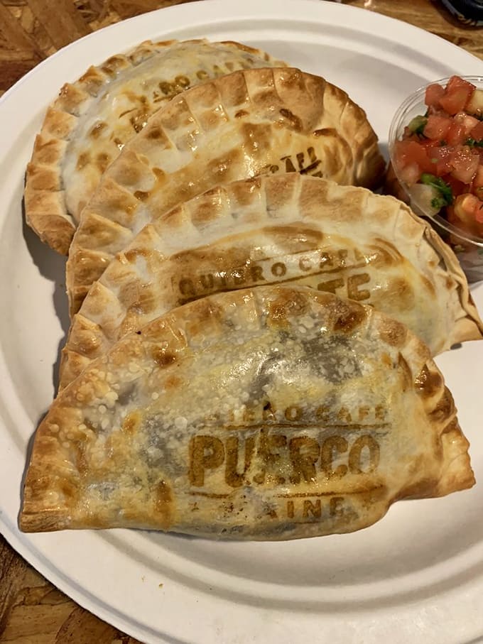 Golden empanadas stamped with the Quiero logo arrive like edible love letters, crispy on the outside and bursting with flavor within.