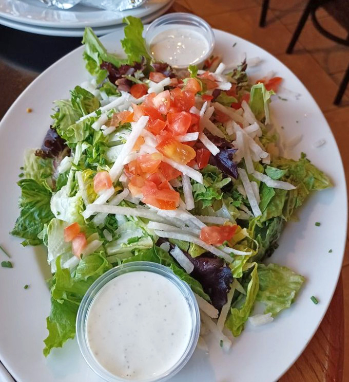A fresh garden salad provides the illusion of virtue before diving into heartier fare &ndash; crisp greens topped with diced tomatoes and shredded cheese.