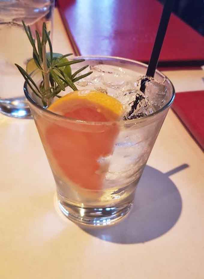 This cocktail arrives looking like summer in a glass, complete with fresh herbs and citrus that make you forget you're hundreds of miles from any ocean.