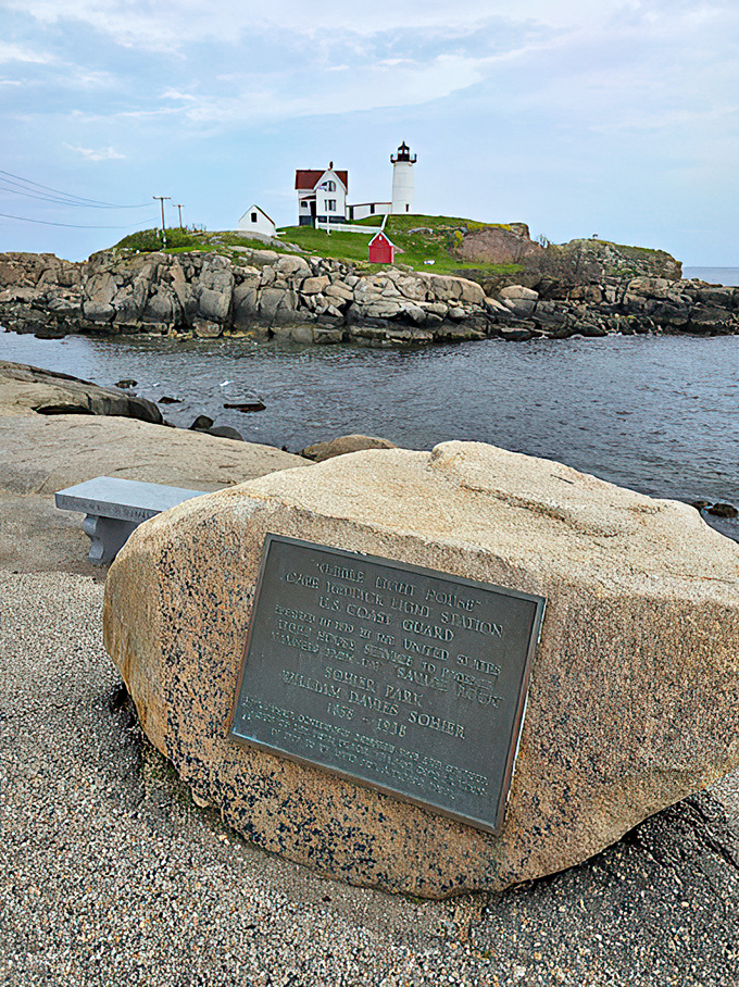 History carved in stone: A memorial marker shares the lighthouse's story while waves provide the background music.