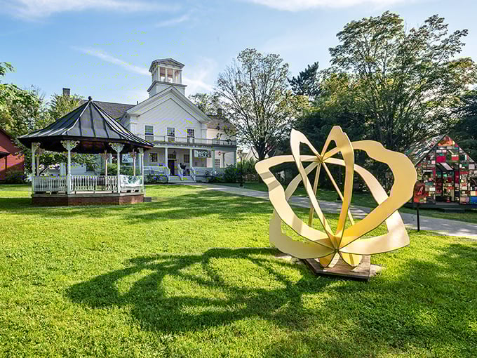 Golden sunlight bathes the village green, where a modern sculpture creates fascinating contrast with traditional New England architecture.