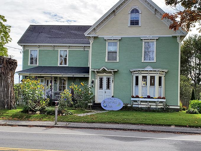 The Nightfall Inn's mint-green Victorian facade and welcoming porch promise comfortable accommodations with historic character.