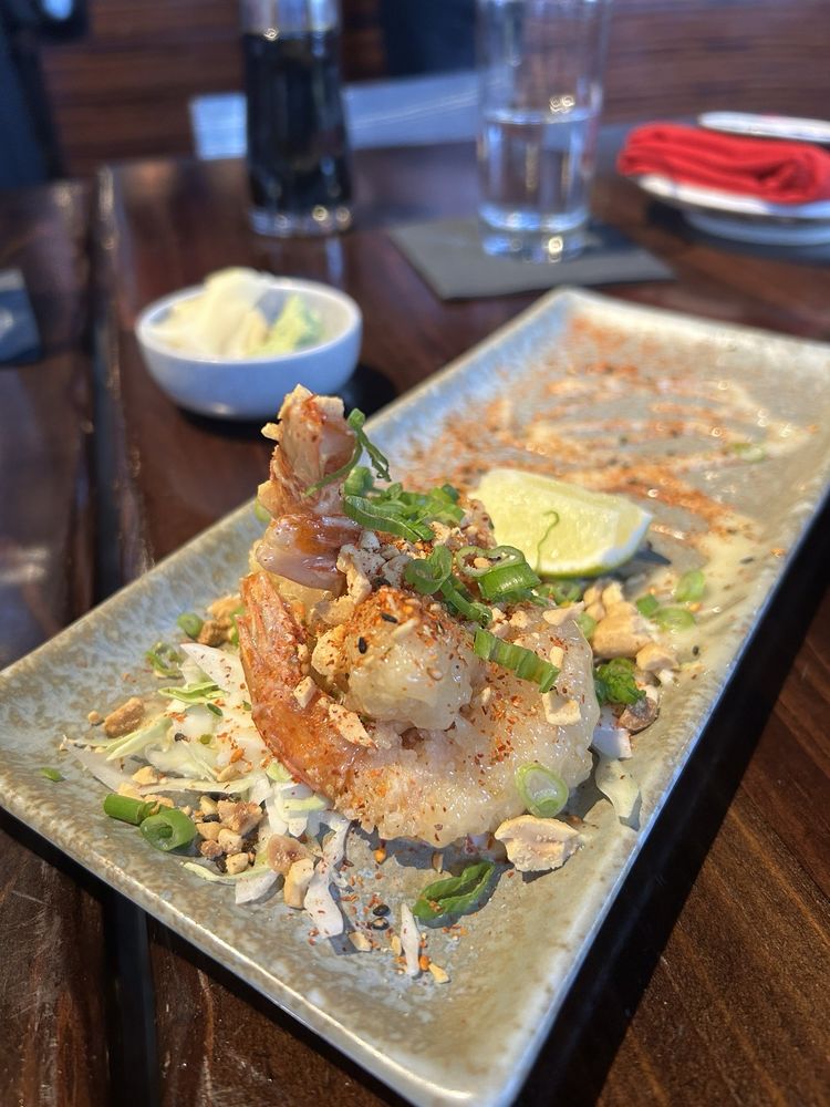 These succulent shrimp aren't just food, they're a work of art – garnished with scallions and spices atop a canvas of ceramic.