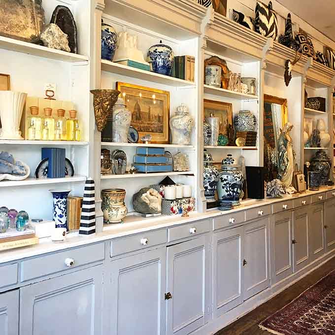 Stacked books, classical busts, and brass candlesticks create a vignette that would make even the most jaded interior designer pause and pull out their phone.