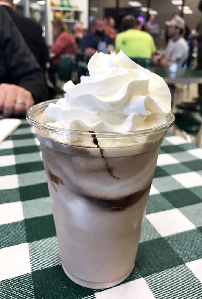 The chocolate malt arrives with enough whipped cream to require architectural support, thick enough to eat with a spoon if you prefer.