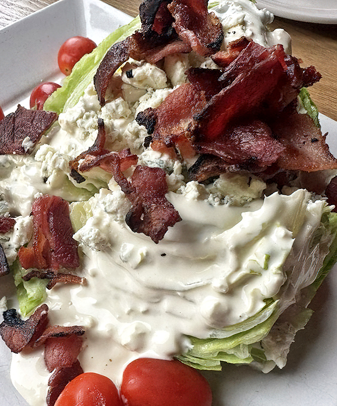 A wedge salad that's practically architectural&mdash;crisp iceberg, bacon crumbles, and blue cheese dressing in perfect harmony.
