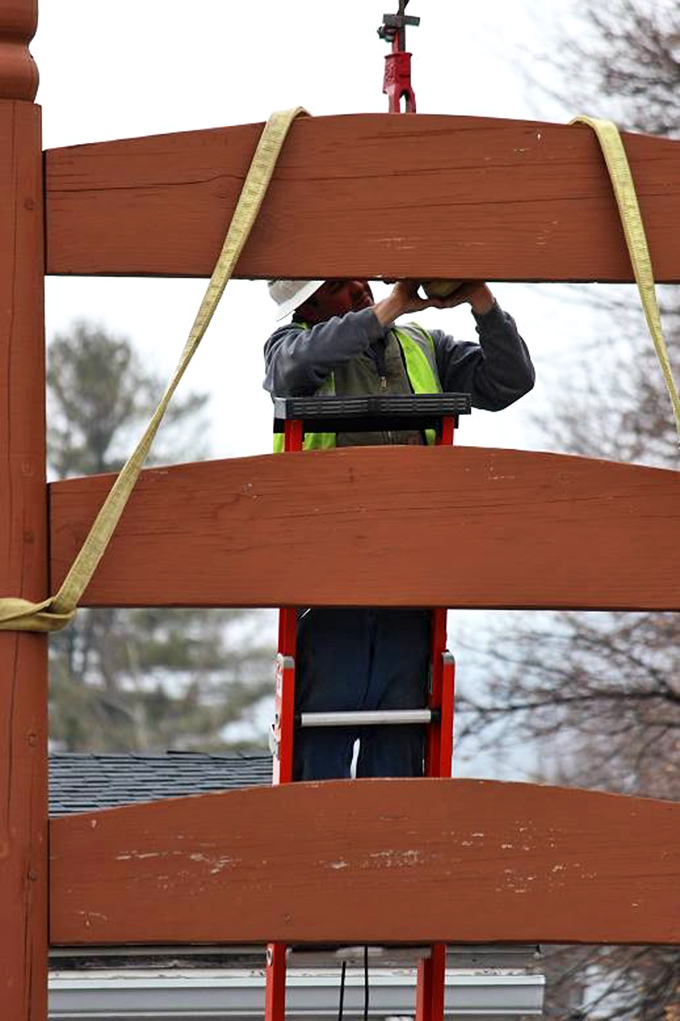 A maintenance worker tends to the chair, ensuring this wooden wonder remains standing for future generations. Chair doctors make house calls, but this one requires a ladder truck.