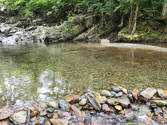 Crystal-clear waters of Gold Brook reflect centuries of history and heartbreak, flowing beneath the bridge where Emily's spirit allegedly remains.