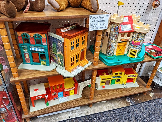 Colorful vintage Fisher-Price playsets line wooden shelves, their retro buildings and playsets recalling childhoods from simpler, pre-digital times.