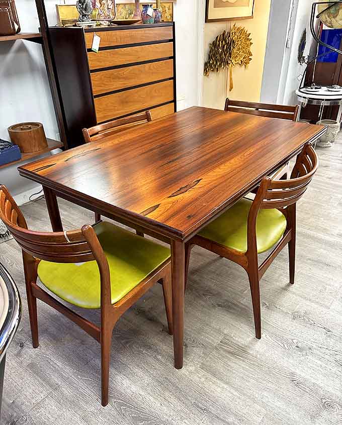 A rosewood dining table surrounded by chairs with avocado upholstery &ndash; the kind of vintage find that makes interior designers swoon.