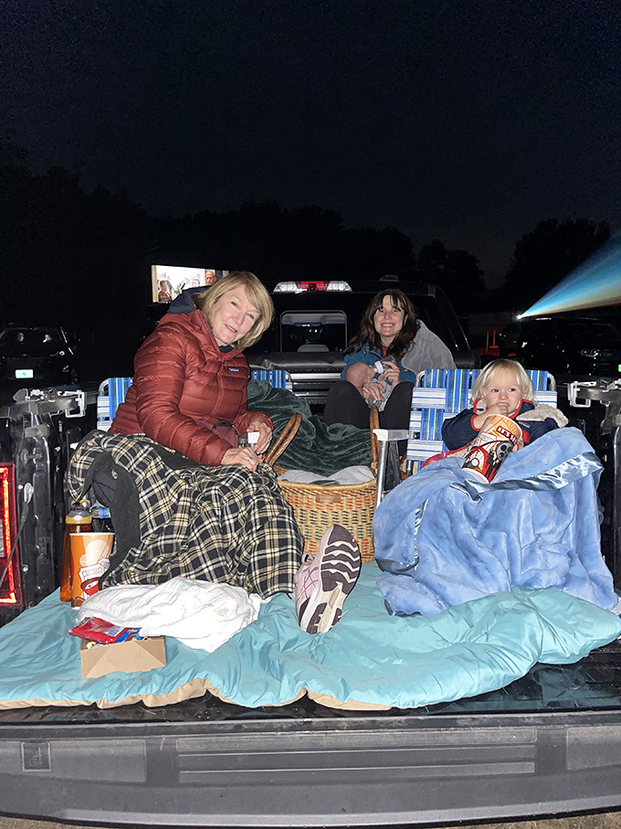 Blankets, pickup trucks, and family togetherness create the perfect viewing setup for an evening of outdoor entertainment.