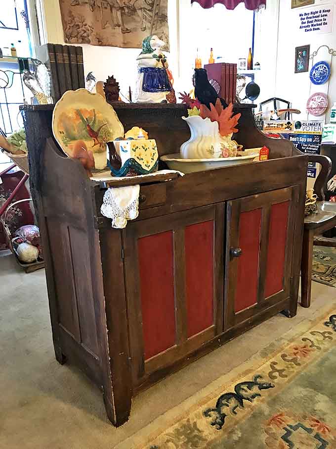 A primitive dry sink with its original red panels tells stories of kitchens long before modern plumbing changed domestic life.