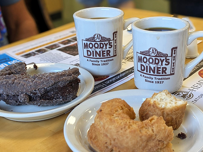 Coffee mugs proudly displaying the Moody's logo alongside chocolate and plain donuts &ndash; breakfast of champions, Maine edition.