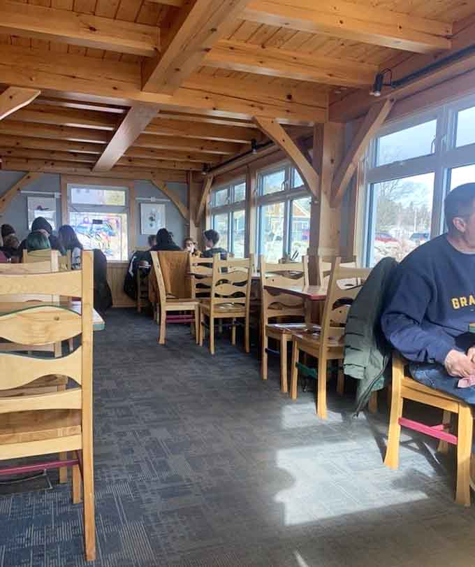 Diners enjoying their meals in a space where wood, windows, and water views create the perfect dining atmosphere.