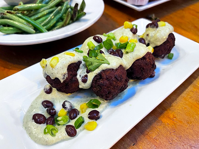 Black Bean Fritters arrive draped in creamy sauce, studded with corn and scallions &ndash; crispy outside, tender within, and altogether more exciting than beans have any right to be.
