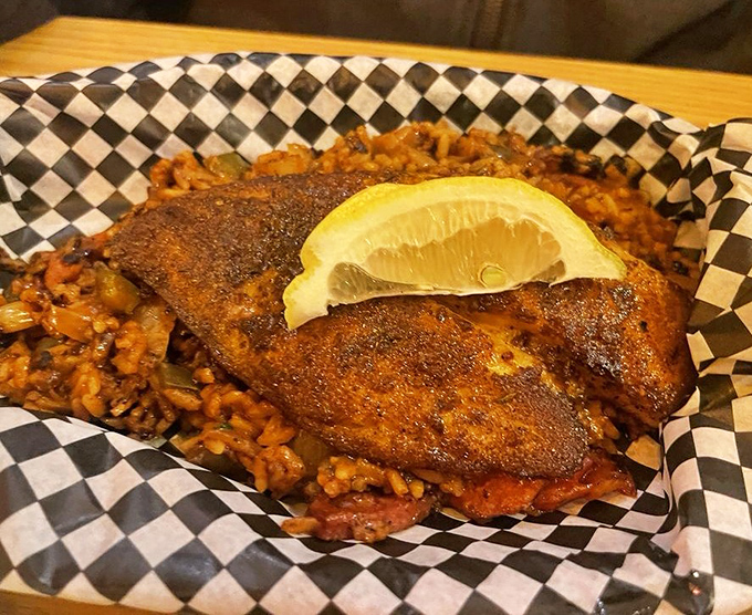 Blackened fish resting on jambalaya is Cajun harmony on a plate. That lemon wedge isn't just garnish—it's the perfect bright note to cut through the richness.