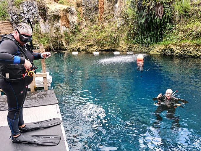A teaching moment unfolds in crystal clear waters, where diving skills are passed from instructor to student with patience.