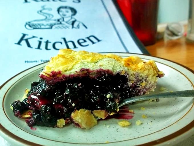 Wild Maine blueberry pie served warm with vanilla ice cream, a purple-stained spoonful of summer in every bite.