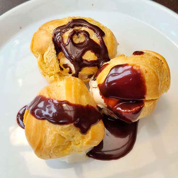Profiteroles drizzled with chocolate sauce are the sweet ending your pasta dinner deserves, light enough to finish but indulgent enough to satisfy.