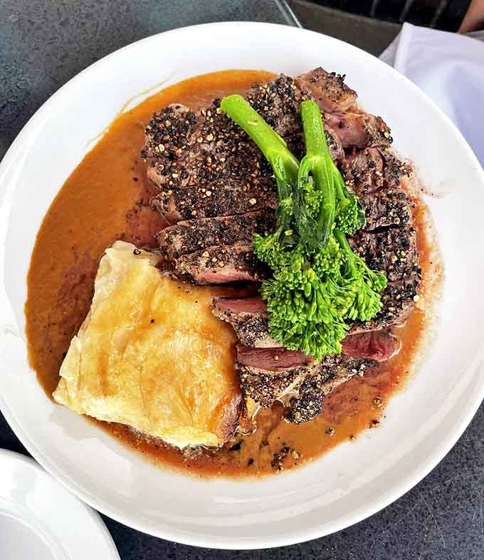 This isn't just steak, it's a masterclass in meat preparation &ndash; perfectly seared ribeye with a pat of melting herb butter that creates its own luxurious sauce.