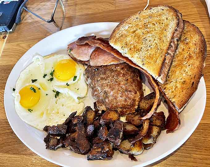 Breakfast perfection on a plate &ndash; sunny-side eggs, house-made sausage, and crispy potatoes that would make any morning person out of night owls.