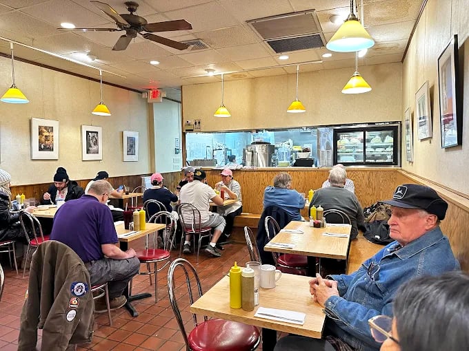 The dining room hums with satisfaction &ndash; red vinyl chairs supporting generations of customers united by their love of proper deli food.