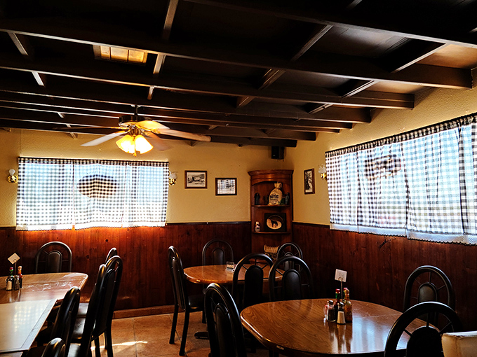 Checkered curtains filter desert sunlight into this cozy dining area where strangers become friends over shared food revelations.