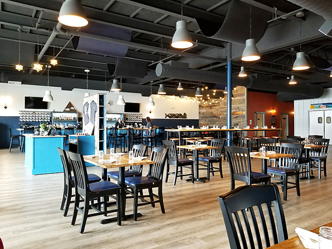 The dining area balances nautical charm with Caribbean cool &ndash; those blue accents pop against warm woods like ocean against sand.