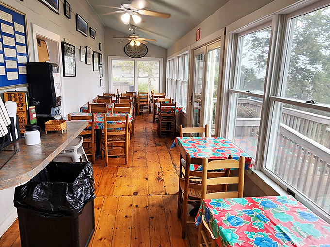 Rustic wooden floors and walls of windows create a sun-drenched dining room where coastal breezes complement every bite.