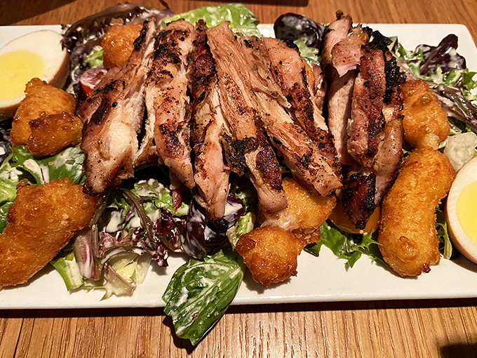 Succulent grilled meat nestled among crispy potato bites on a bed of fresh greens &ndash; a protein-packed feast that satisfies on every level.