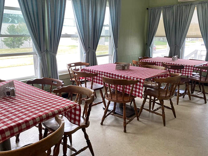 Sunlight streams through windows onto a sea of red and white tablecloths, creating an atmosphere that's both cheerful and timelessly classic.