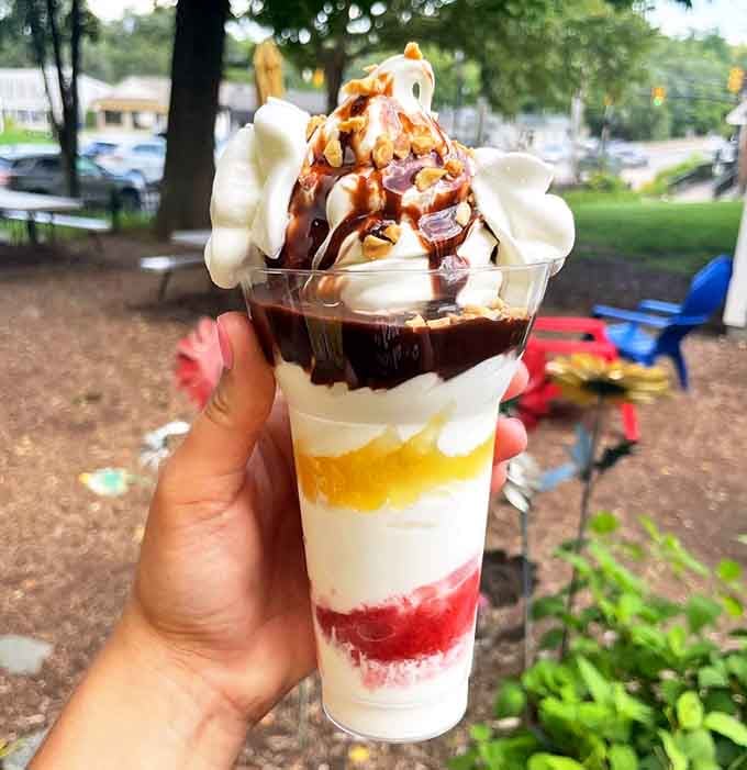 Layered parfait perfection: A rainbow of flavors stacked in perfect harmony &ndash; fruit, cream, and sauce creating edible art.