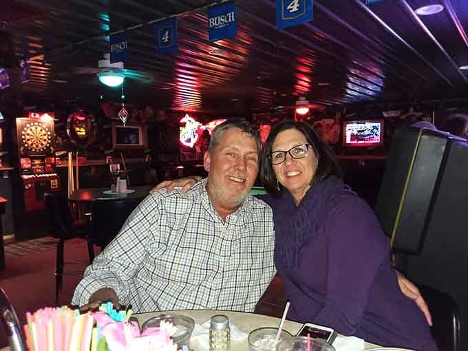 Happy diners enjoying the neon glow, proof that good food makes everyone photogenic.