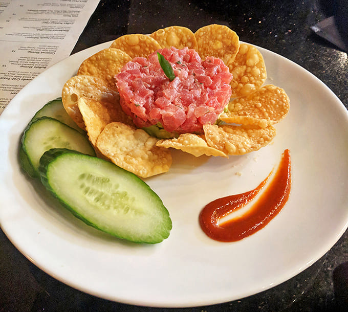 Raw elegance: The tuna tartare arrives like edible art, surrounded by crisp wonton chips &ndash; ocean freshness meets architectural precision.