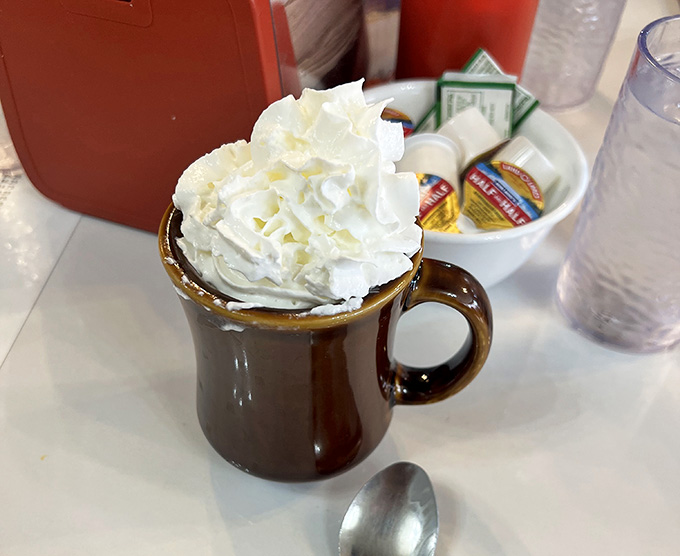 Hot chocolate crowned with whipped cream that defies gravity, perfect for those who take their beverages seriously sweet.