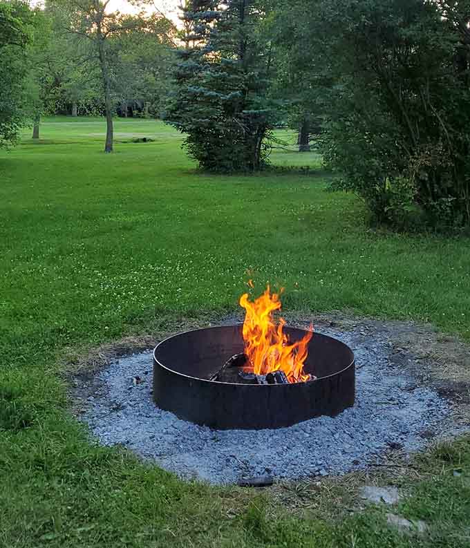 A fire pit surrounded by green grass is basically the outdoor equivalent of a warm hug on a cool autumn evening, marshmallows optional but recommended.