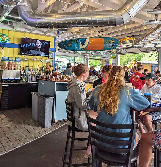 The lively bar area buzzes with conversation and laughter, where strangers become friends over shared plates and cold drinks.