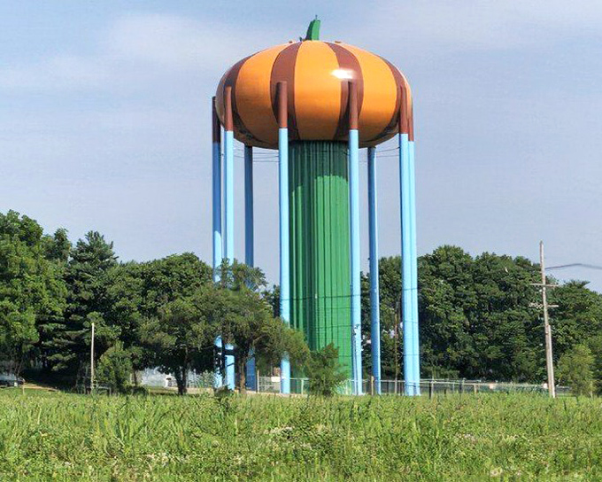 The tower's blue support columns create a striking color contrast with the orange dome, like a children's book illustration come to life.