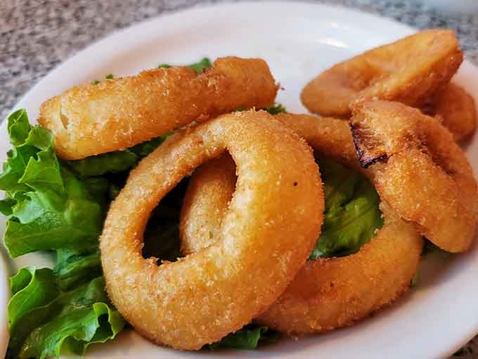 Golden onion rings arrive hot and crispy, perfect for sharing or not sharing, depending on how your day is going.