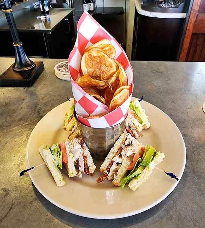 The club sandwich arrives in style, stacked high and served with chips that'll make you forget potato chips come in bags.