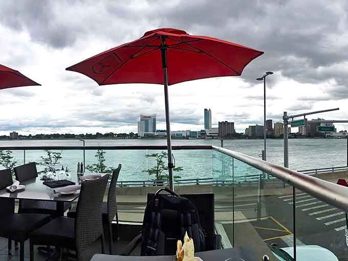 Outdoor dining with a side of spectacular &ndash; red umbrellas frame views of the Detroit River that rival any coastal setting.