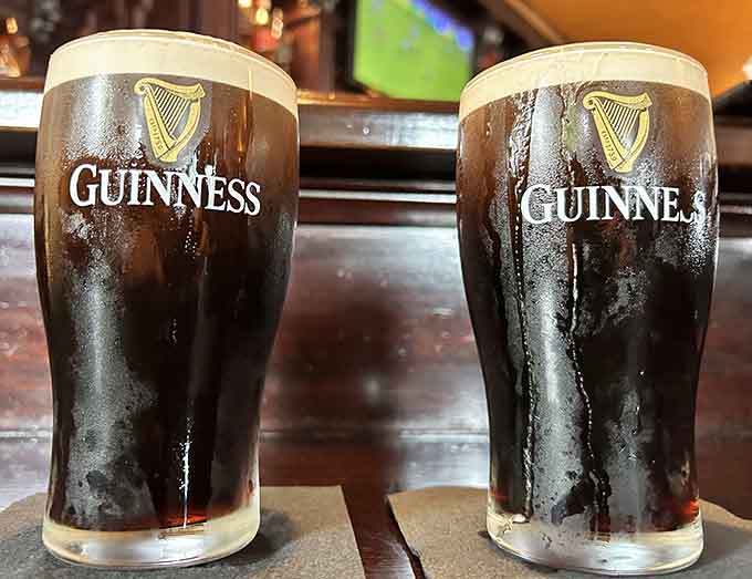 Two perfectly poured Guinness pints stand ready to wash down whatever deliciousness you've ordered, because some traditions are worth maintaining.